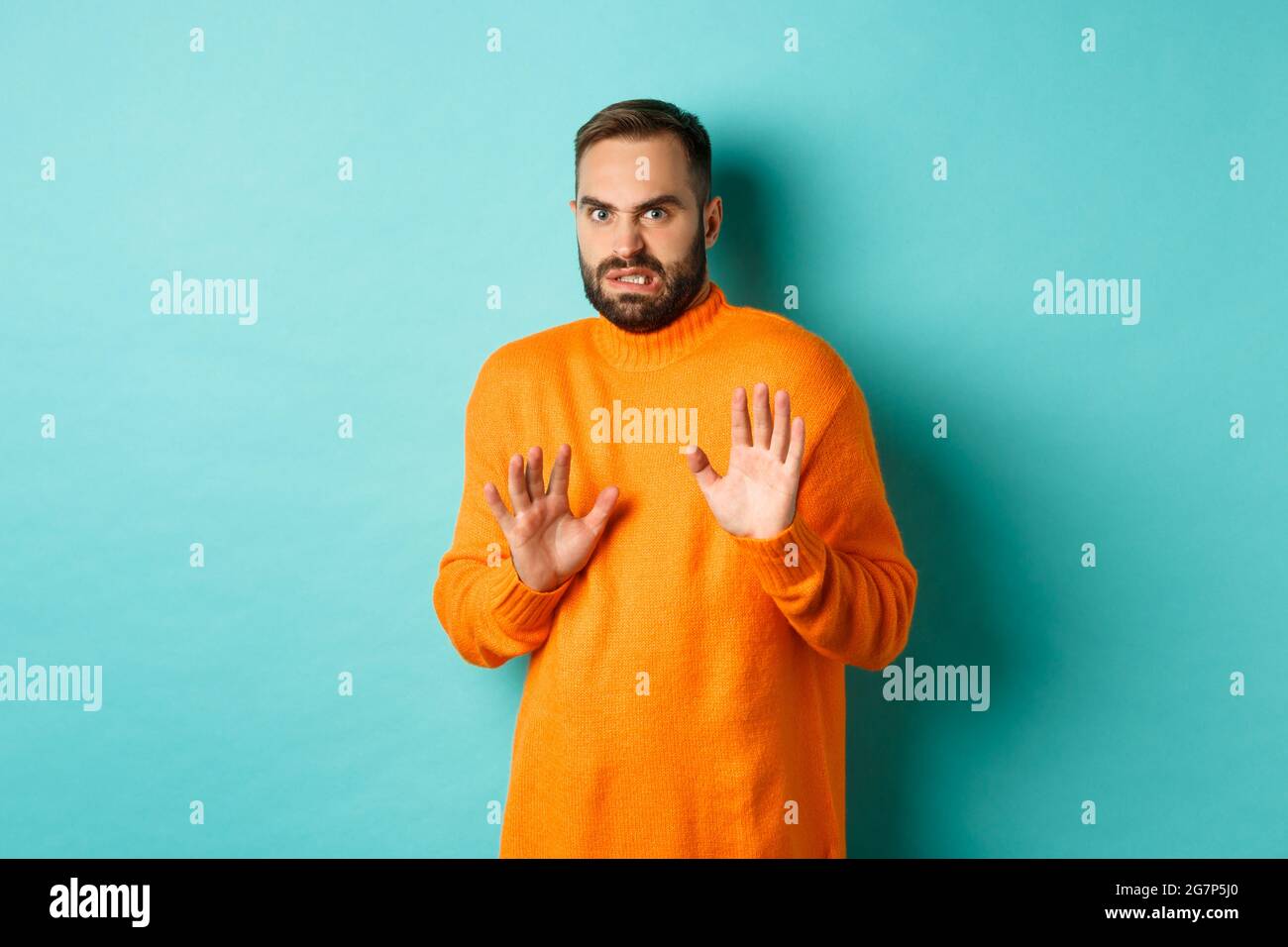 Alarmed guy shaking hands in rejection, declining and stepping away ...