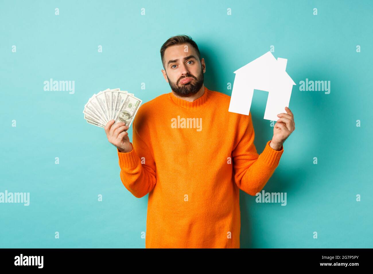 Real estate concept and mortgage concept. Sad and confused man showing ...