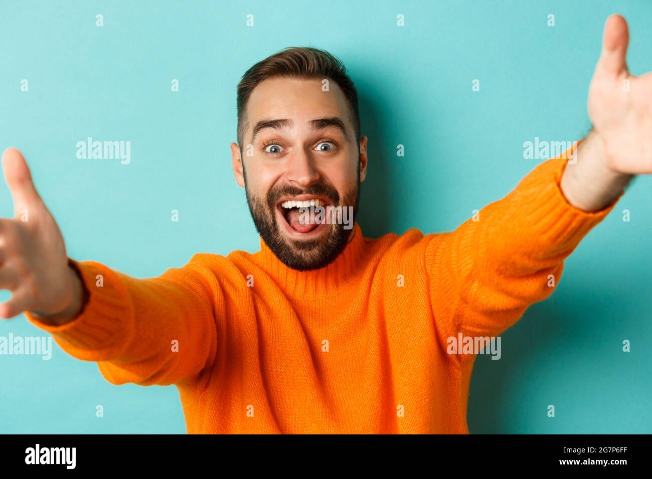 Close-up of handsome happy man reaching hands forward, stretching arms ...