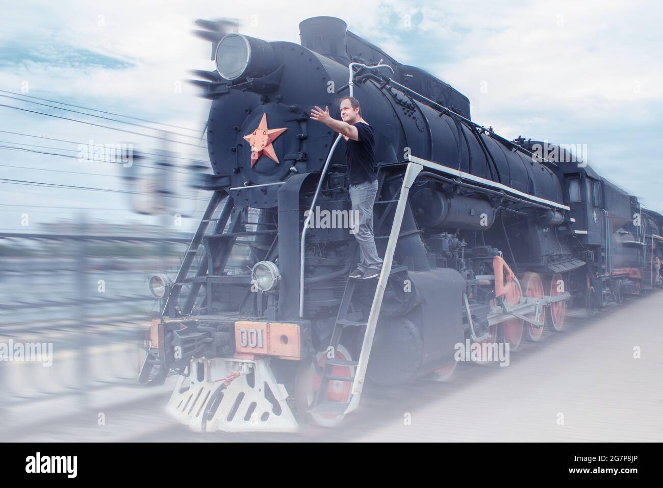 Man stands on a train going. Steam locomotive arrives at station at ...