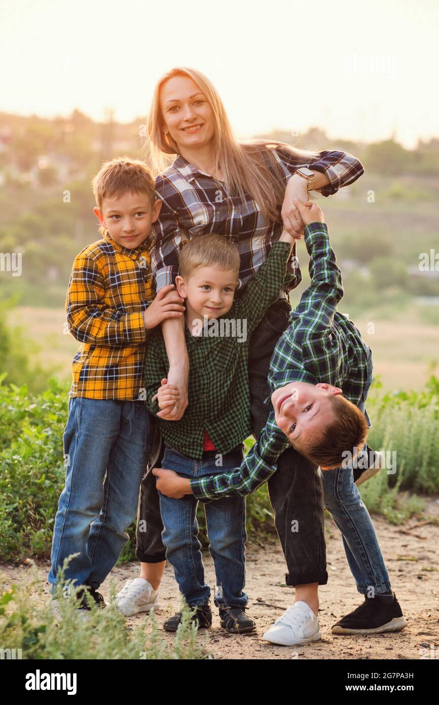 Full-length portrait Young mother and her three son are playing at ...