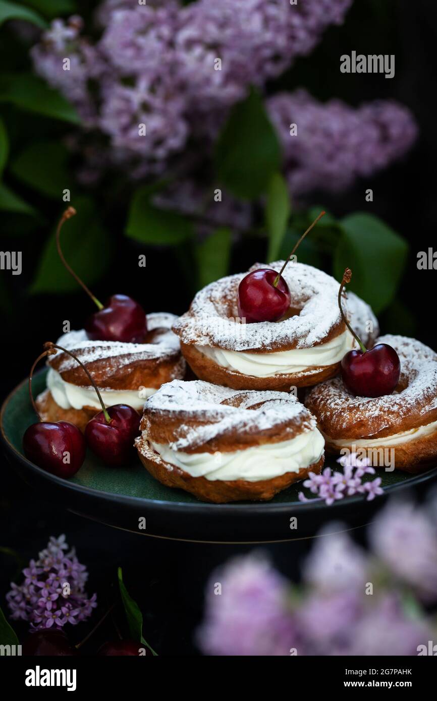 Cream puff rings (choux pastry) decorated with fresh cherry Stock Photo ...