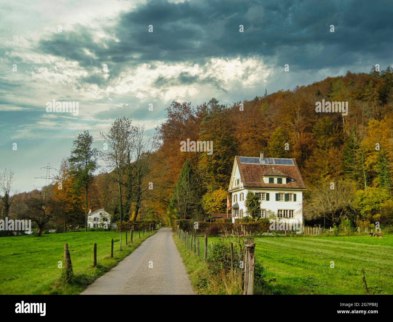Walking trail with houses going to the mountains and forests on a ...