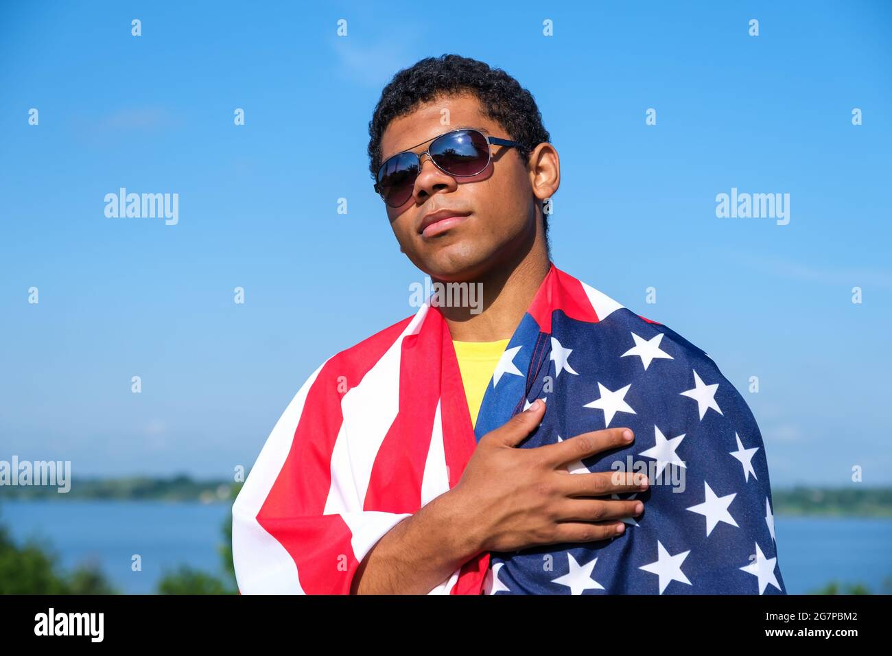Man looking at camera and proudly holding American flag on his ...