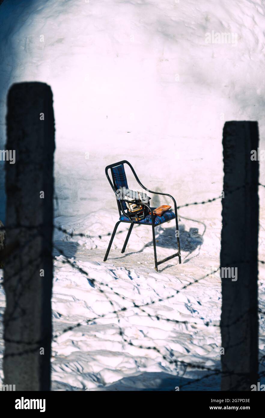 Vertical shot of barbed wires and a chair in a snow-covered area Stock ...