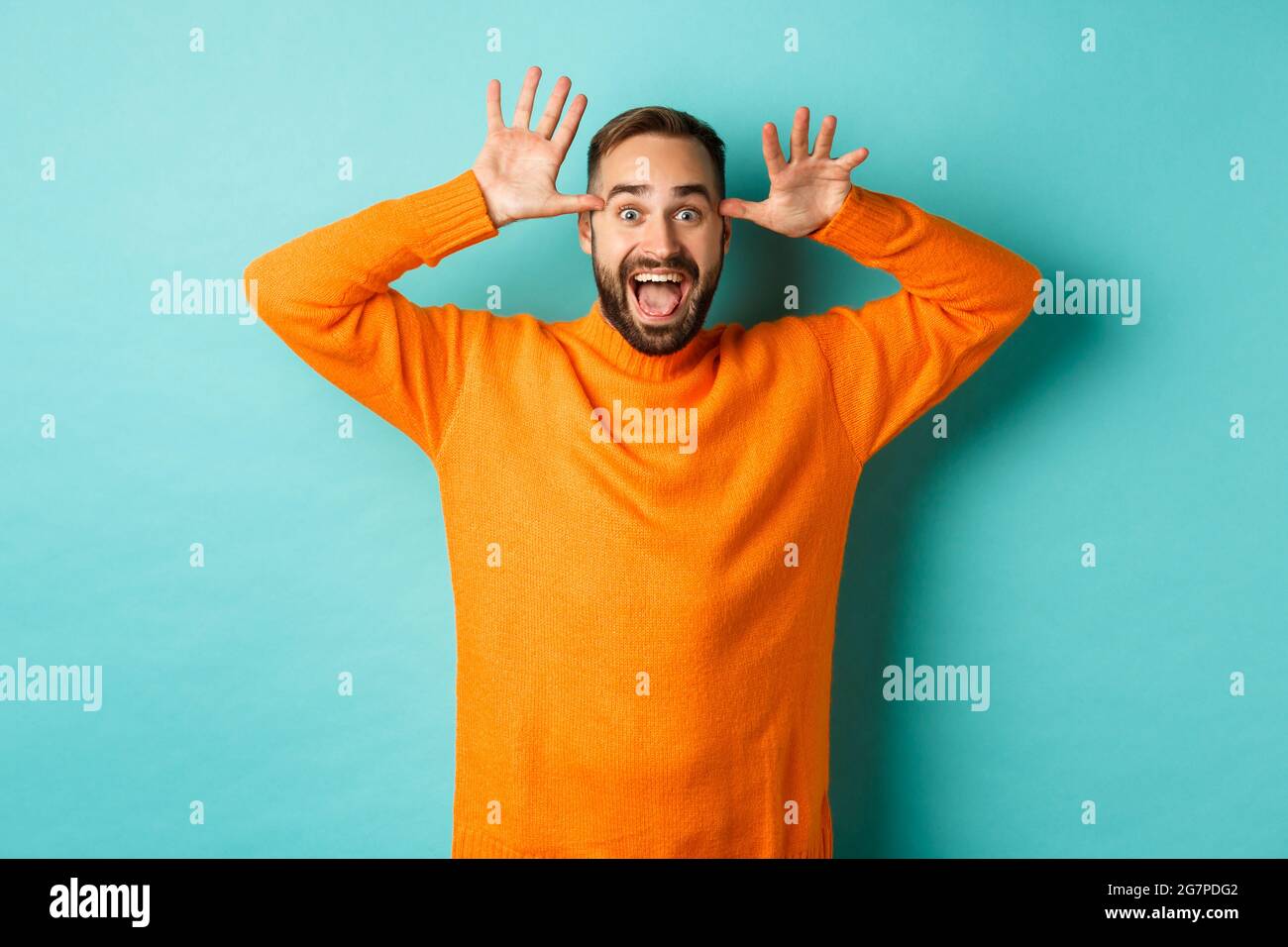 Image of handsome caucasian man making funny faces, mocking someone and ...