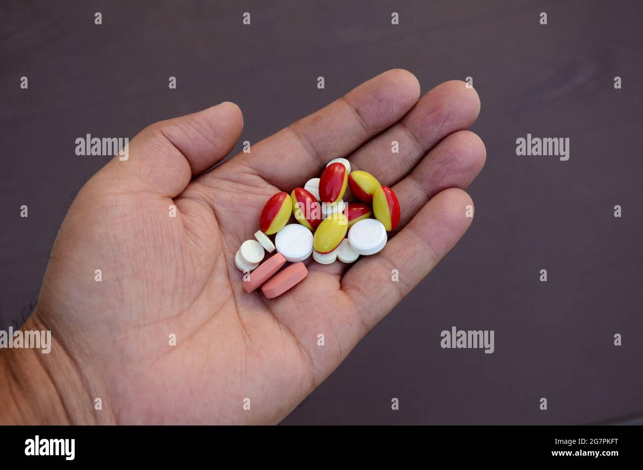 Closeup of pink, white with red, yellow color small medicine tablets ...