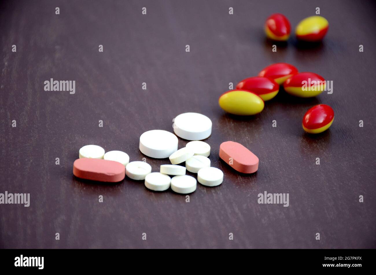 Closeup of pink, white with red, yellow color small medicine tablets ...