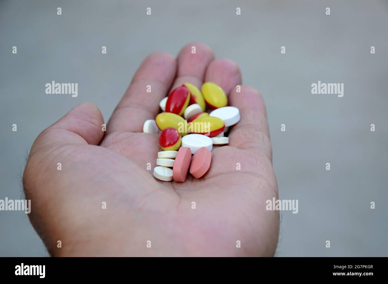 Closeup of pink, white with red, yellow color small medicine tablets ...