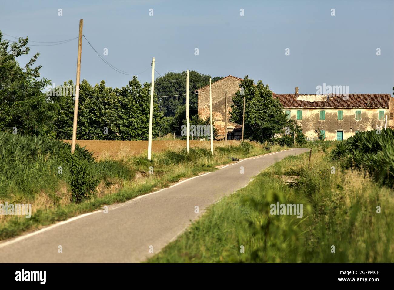 Road in the italian countryside with a mansion in the background on a ...