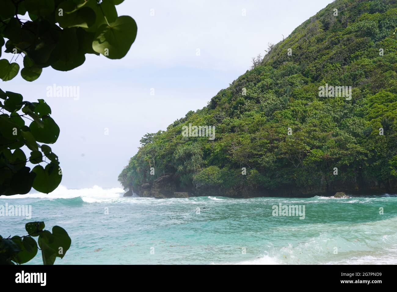 Landscape of the Teluk Asmara Beach surrounded by hills and greenery in ...