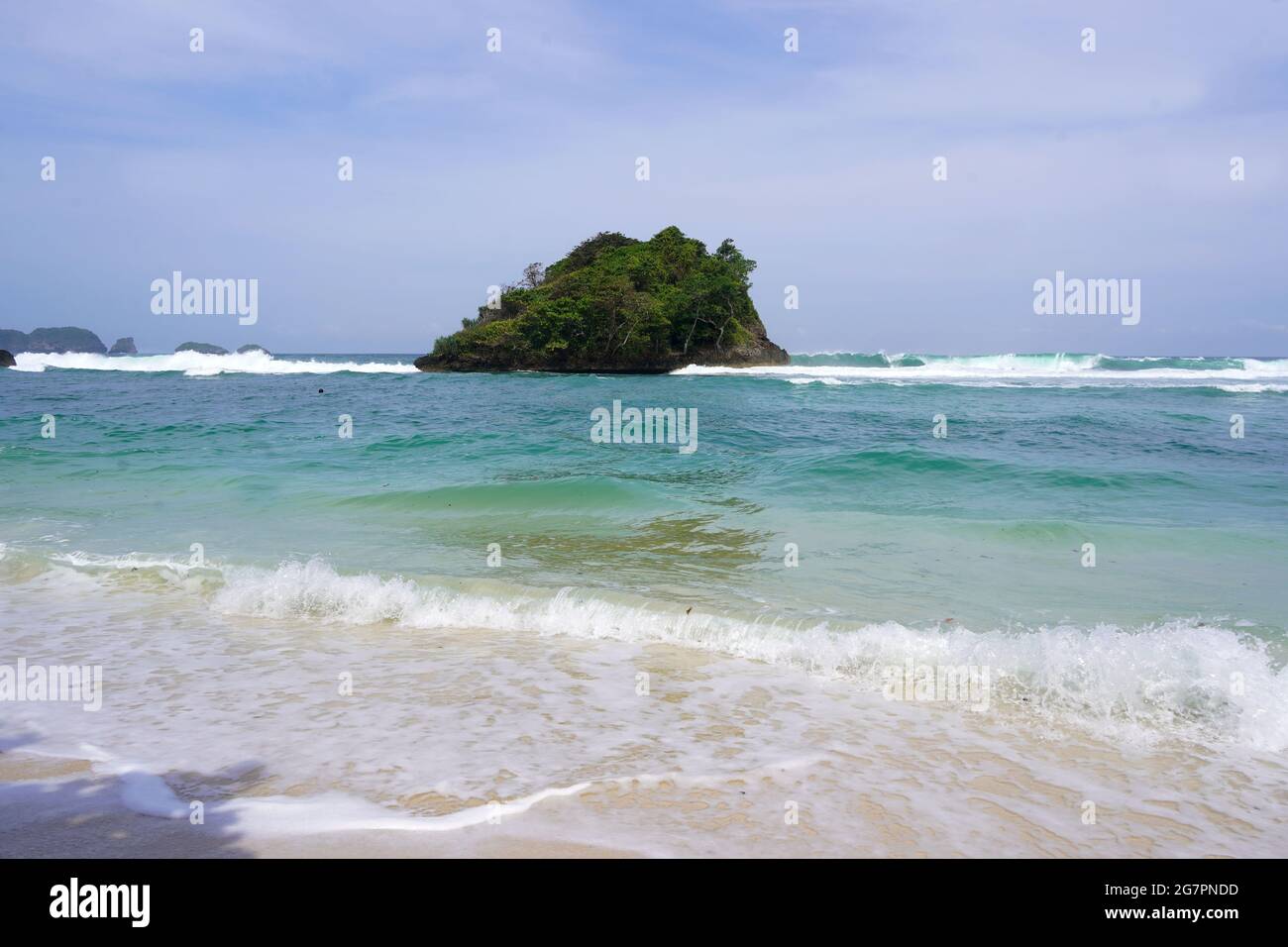 Landscape of the Teluk Asmara Beach surrounded by hills and greenery in ...