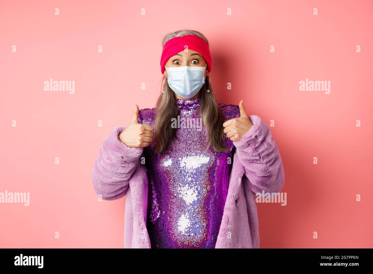 Covid-19, social distancing and fashion concept. Impressed asian senior ...