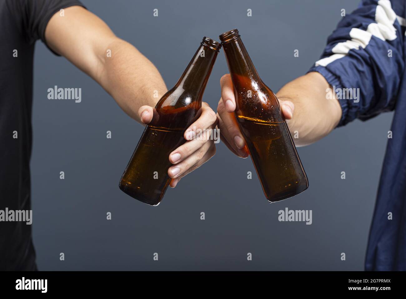 Male hands clinging beer bottles Stock Photo - Alamy