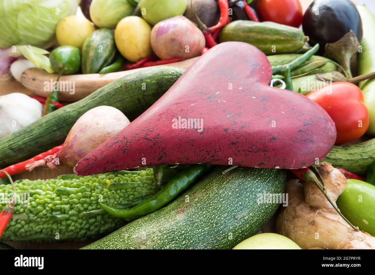 Wooden red heart on top of various fresh organic vegetables Stock Photo ...