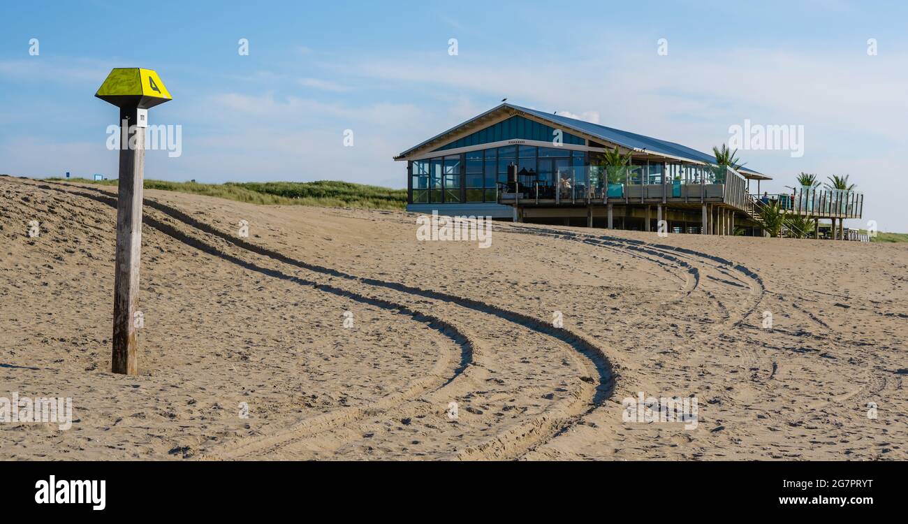 Lone house with glass walls on the beach under a bright blue sky Stock ...