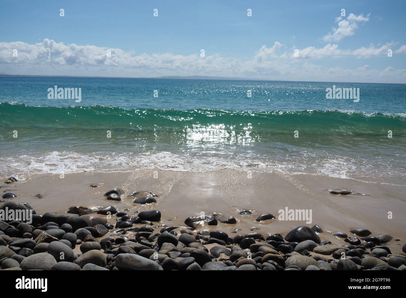 Peaceful view at the foamy waves of the ocean washing the sandy beach ...