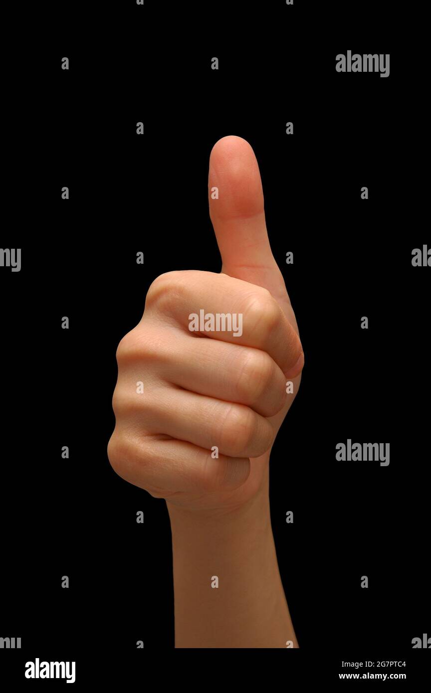 Closeup of a thumbs up hand signal isolated on a black background with ...