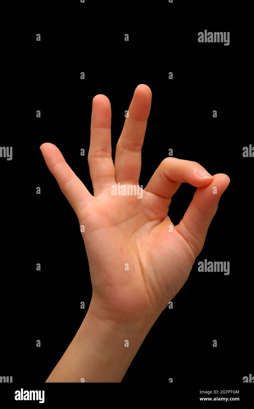 Closeup of an OK hand signal isolated on a black background with free ...