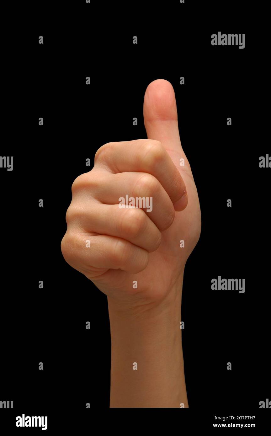 Closeup of a thumbs up hand signal isolated on a black background with ...