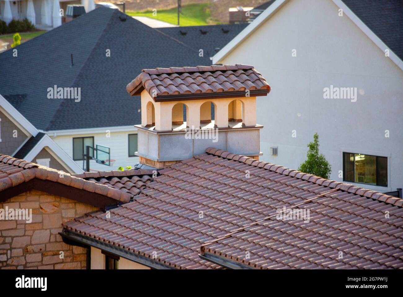 Rooftop with dark red rooftiles and a chimney with a triangle roof ...