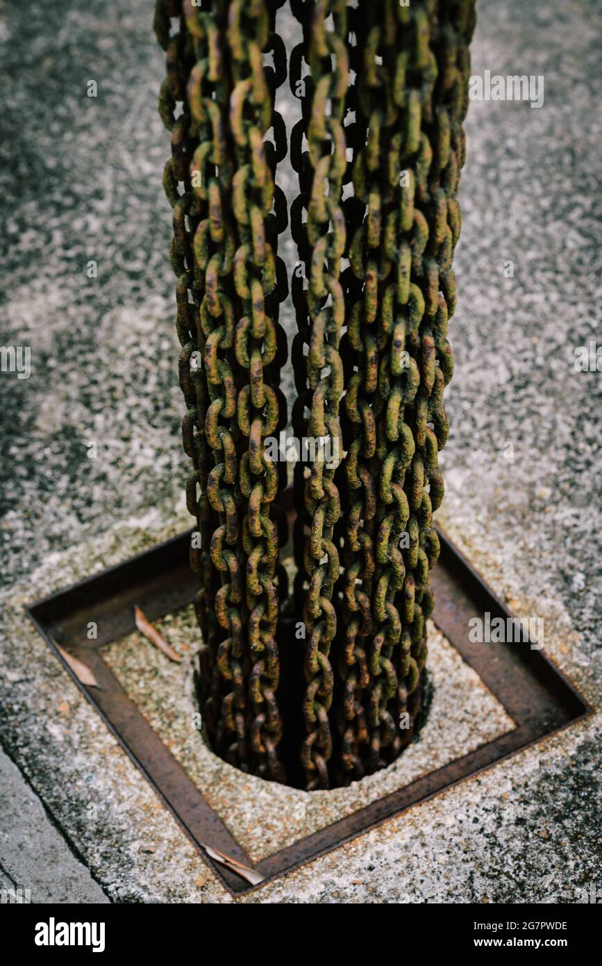 Vertical shot of rusty metal chains hanging in a hole Stock Photo - Alamy