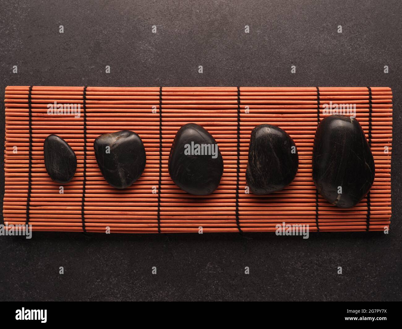 Five hot stones massage stones on a bamboo mat, health care ...