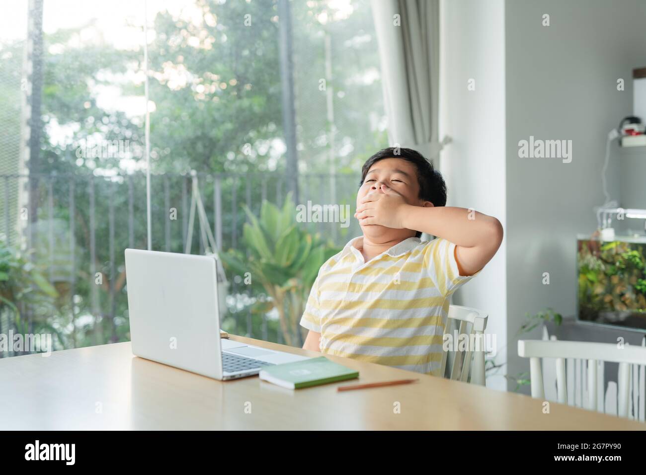 Bored kid boy at home schooling Stock Photo - Alamy