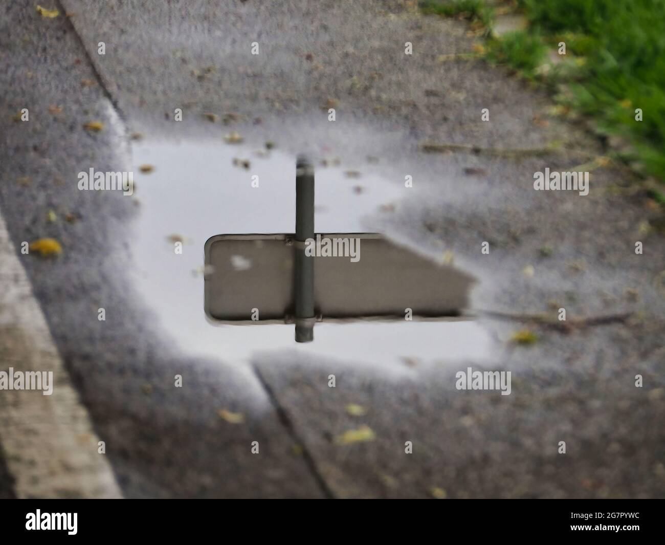 Selective focus shot of a road sign reflected in a puddle Stock Photo ...