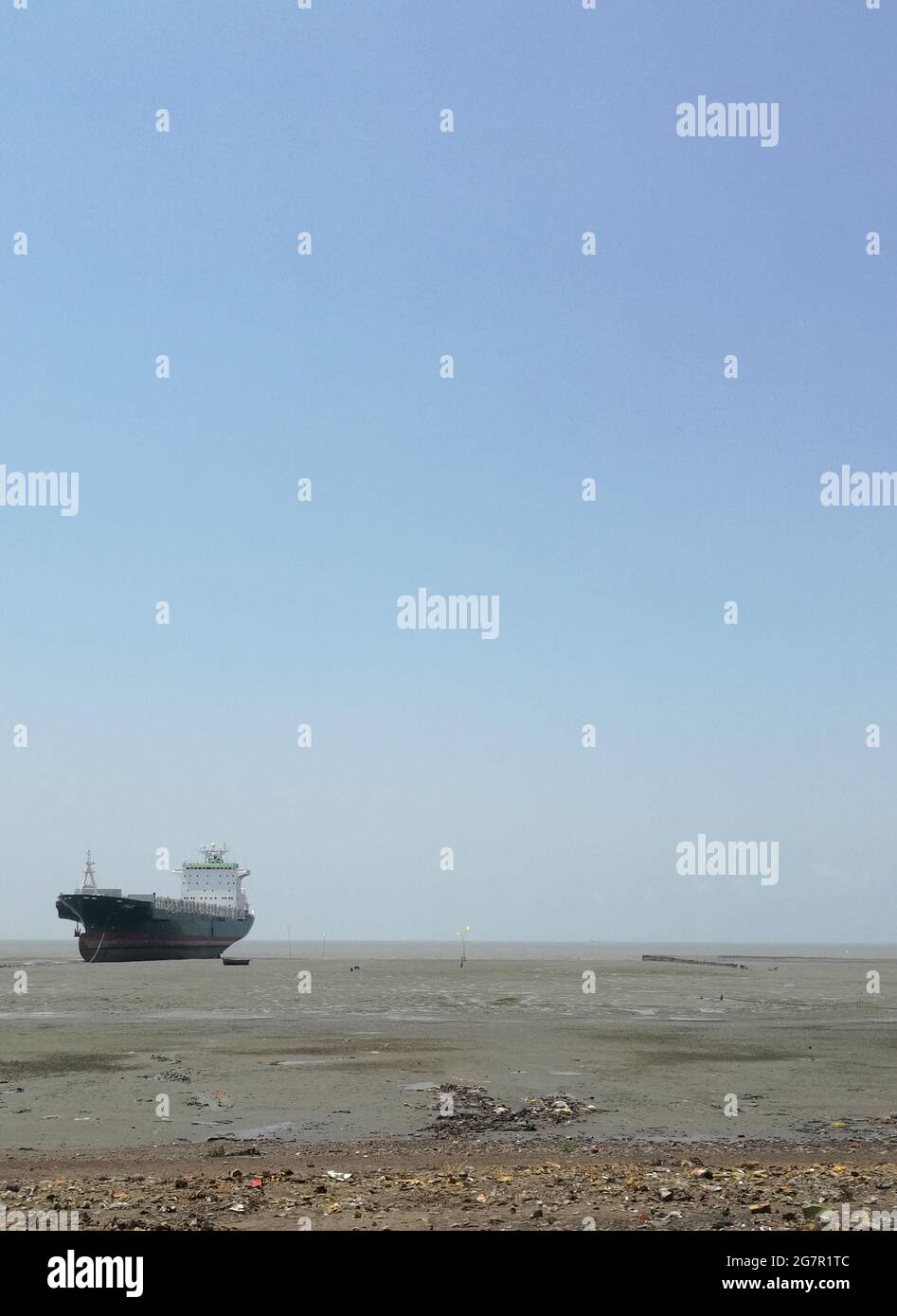 Vertical shot of a huge ship sailing alone in shallow waters under a ...