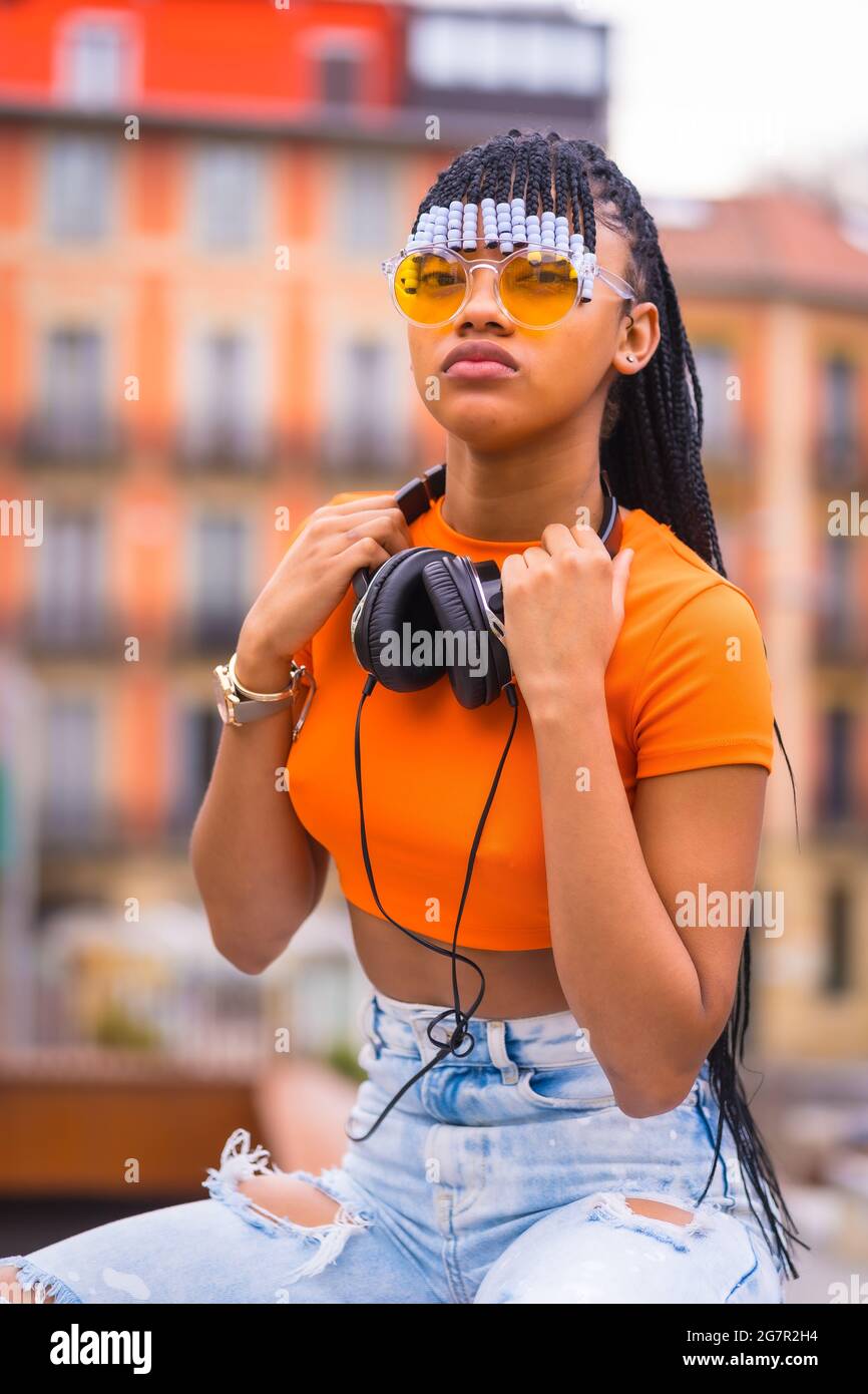 Native American trap dancer with braids wearing an orange shirt and ...
