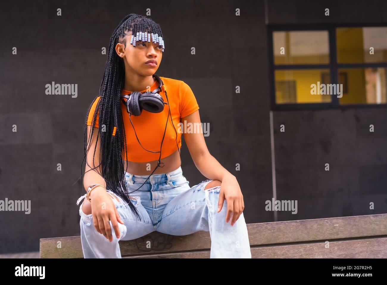 Young native American trap dancer with braids wearing an orange shirt ...