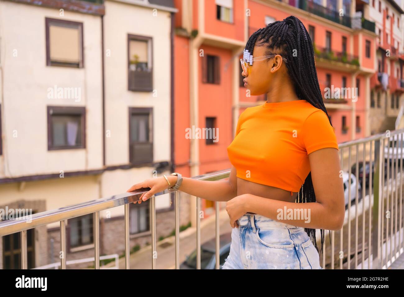 Native American trap dancer with braids in an orange t-shirt and jeans ...