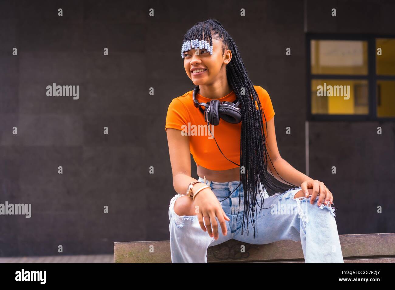 Smiling native American trap dancer with braids wearing an orange shirt ...