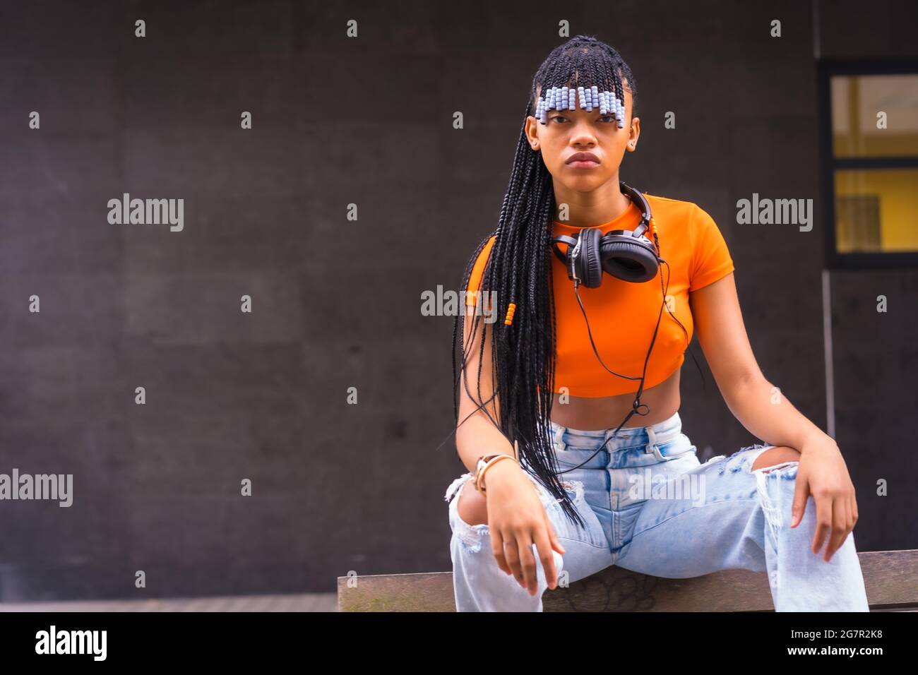 Young native American trap dancer with braids wearing an orange shirt ...
