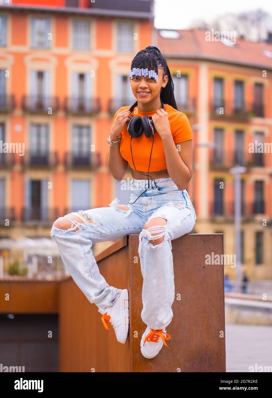 Smiling native American trap dancer with braids wearing an orange shirt ...