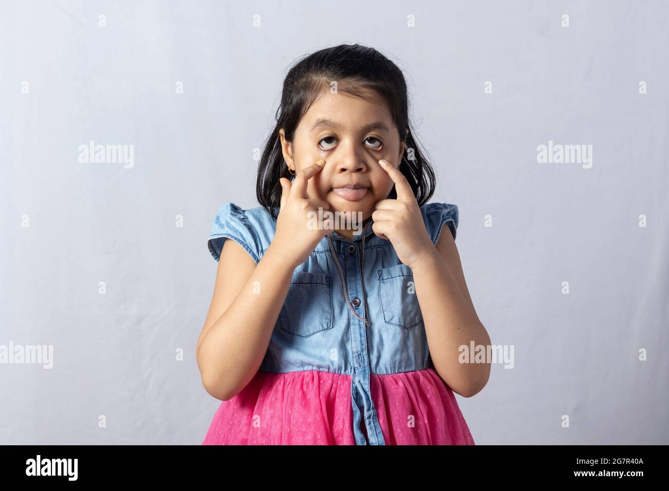 A pretty cute Indian girl child making a face isolated on white ...