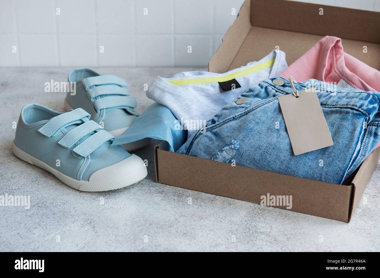 Clothes for kids in an open cardboard box. Online shopping concept ...