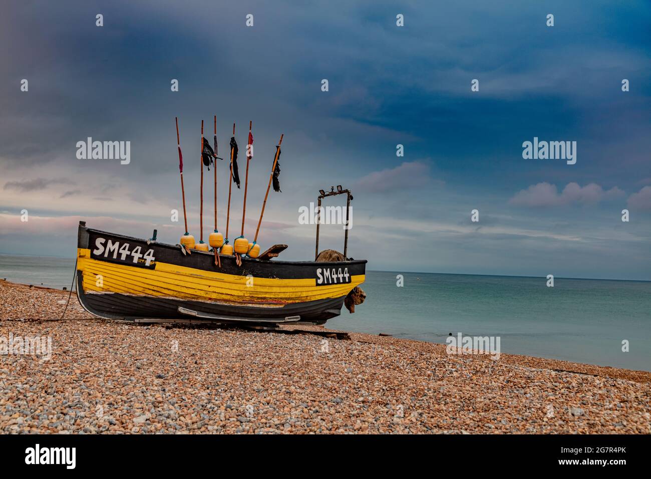 Yellow ship moored at the rocky coast under cloudy sky Stock Photo - Alamy