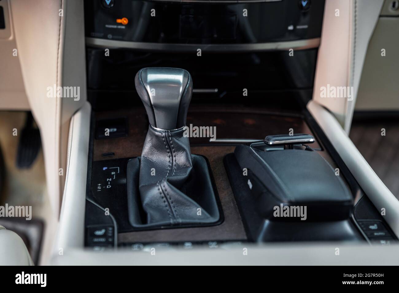 Detail of an automatic gear shifter in a new modern car. Black leather ...