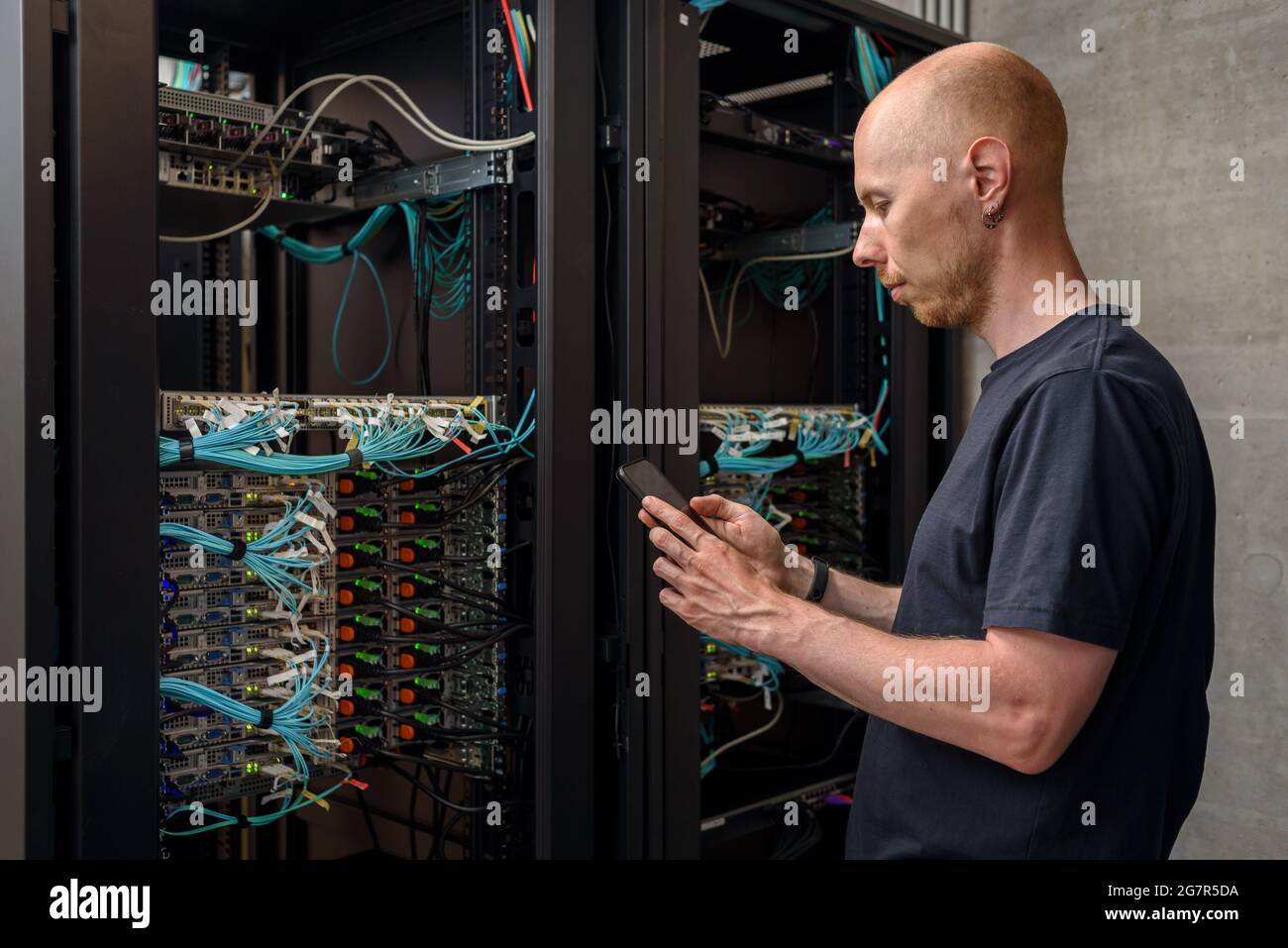 Man data center technician performing server maintenance. Using mobile ...