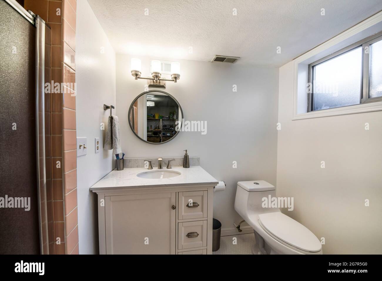 Bathroom interior with window, single vanity sink and one piece toilet ...