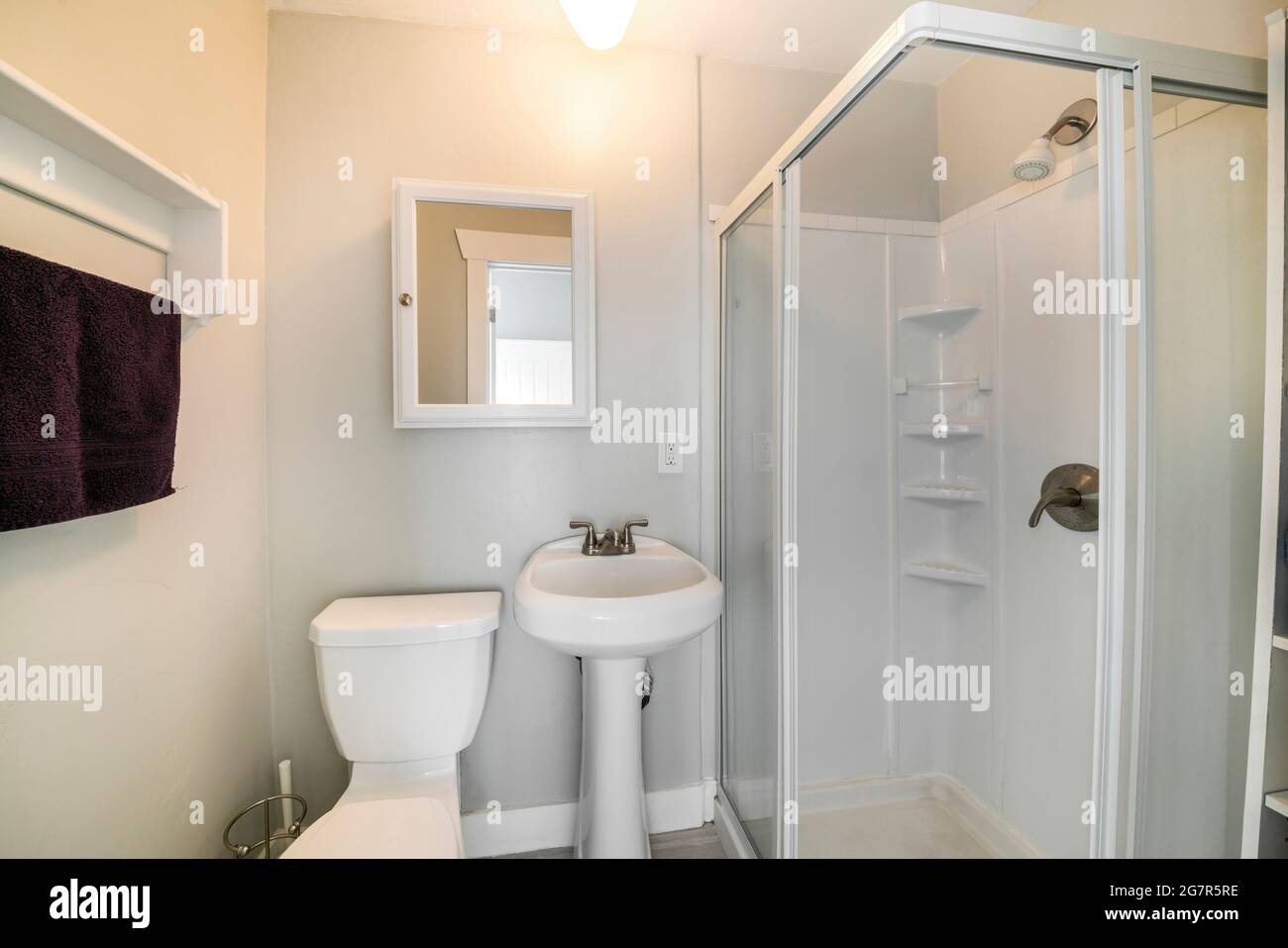 Interior of a small white bathroom with shower stall kit on the side ...