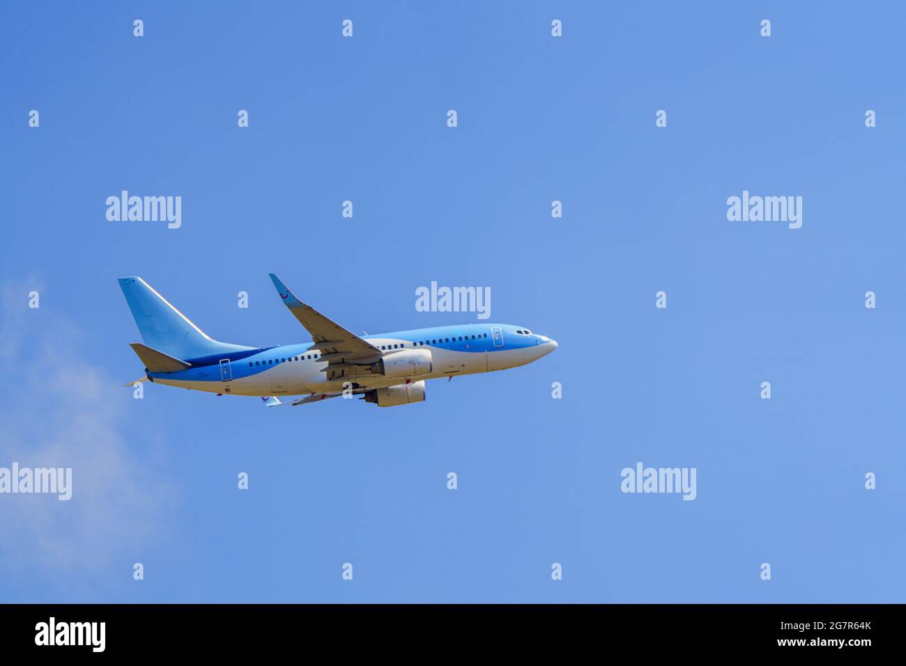 Airplane flying under blue sky Stock Photo - Alamy