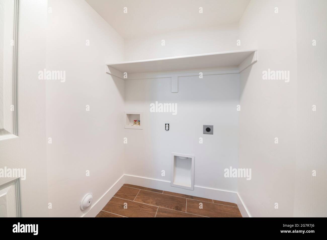 Clean small white empty laundry room with built in laundry connections ...