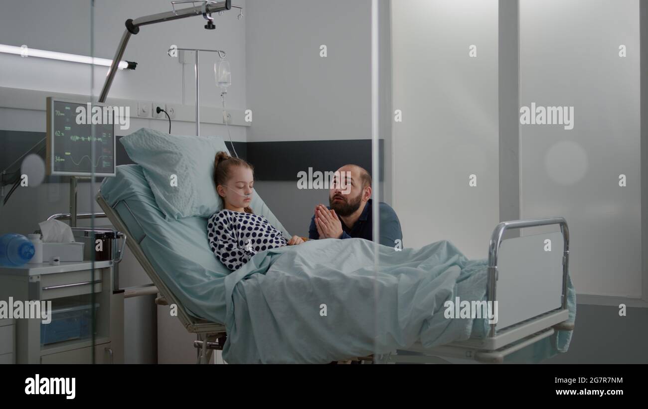 Worried sad father holding hands together praying while waiting ...