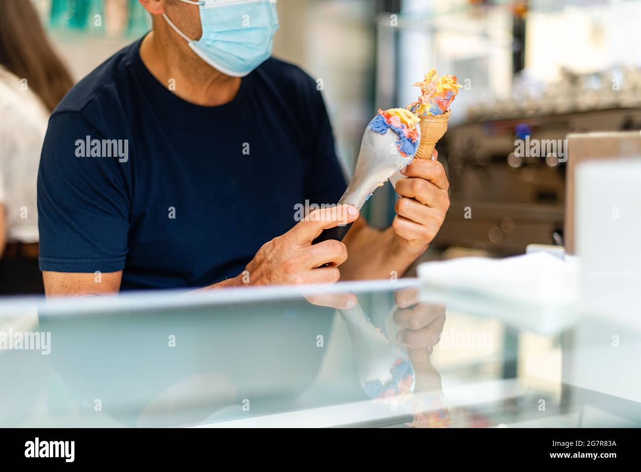 Caucasian male in a protective face mask serving icecream Stock Photo ...