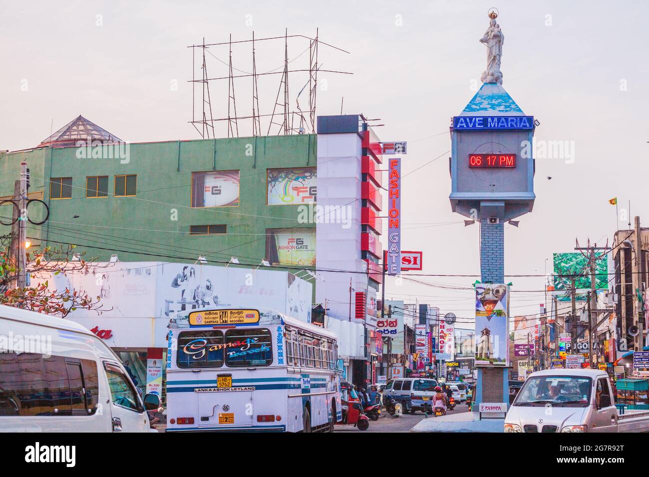 View of busy high street with vehicles, shopfronts and colourful ...