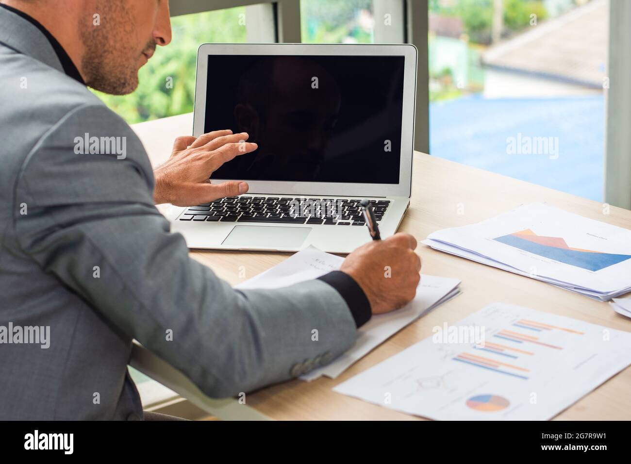 Hand hold pen writing on document, Businessman using computer laptop ...