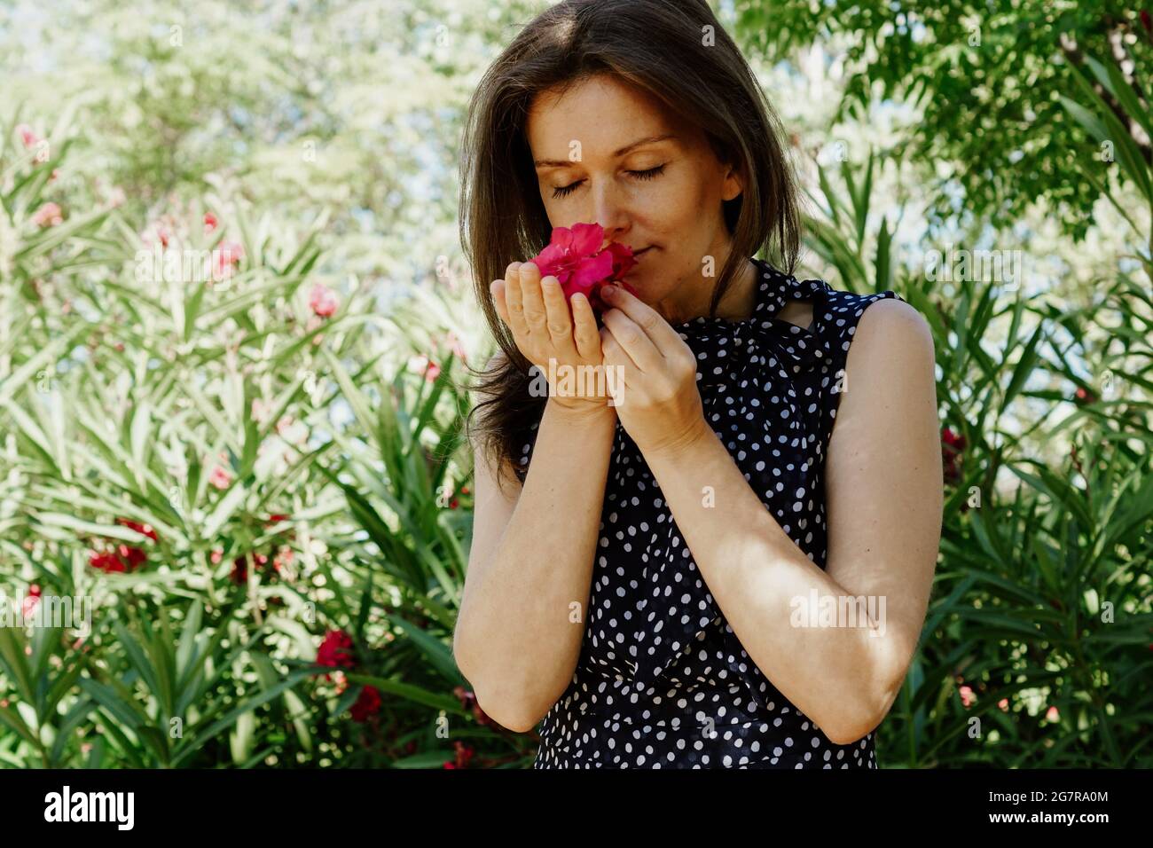 Spanish girl sniffing pink roses Stock Photo - Alamy
